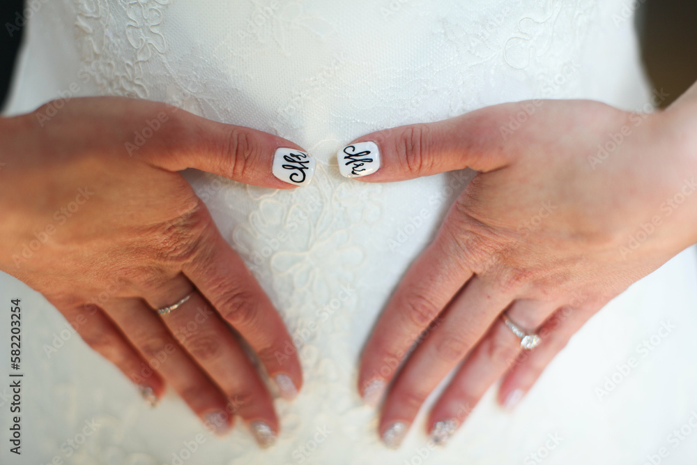 bride holding her hands against her dress, mr and mrs written in ...