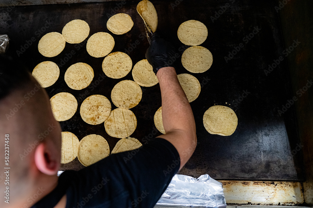 Chef at a mexican restaraunt grilling homemade tortillas on a hot grill ...