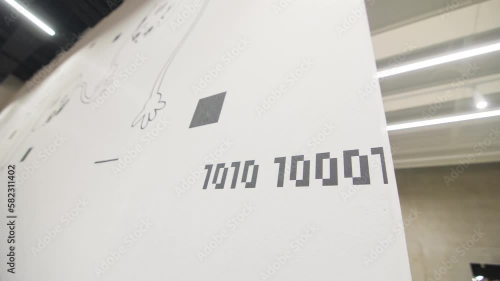 Binary code and funny pictures on white wall in education center for ...