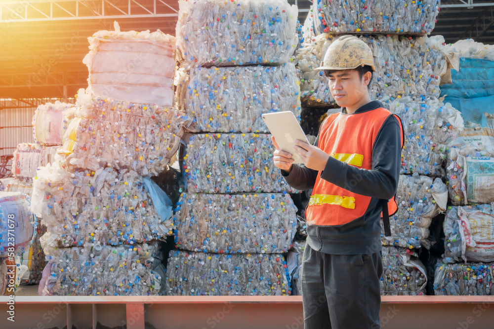 Asian engineer wearing hard hat and protective vest checking data with ...