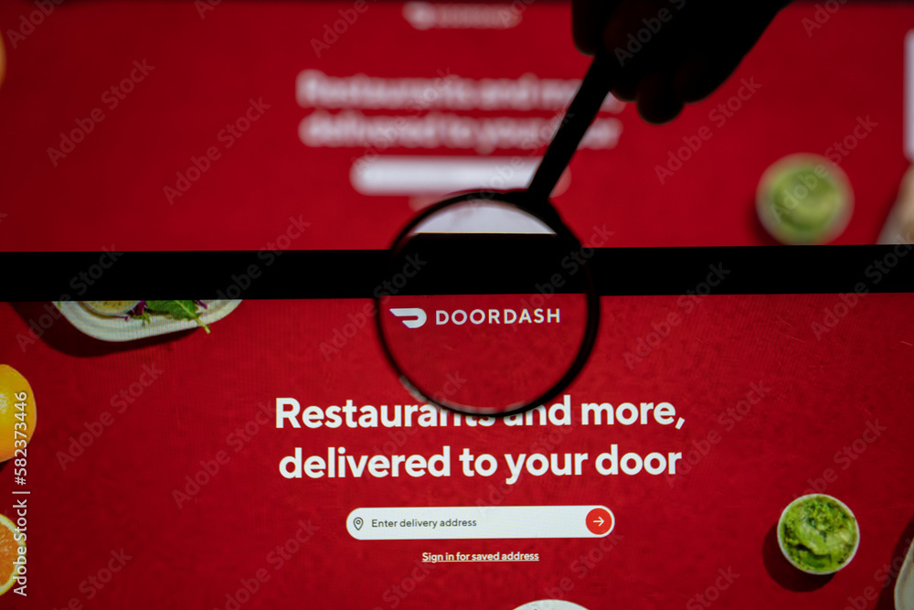 Logo and magnifying glass on Doordash website screen. DoorDash is an American company that ...