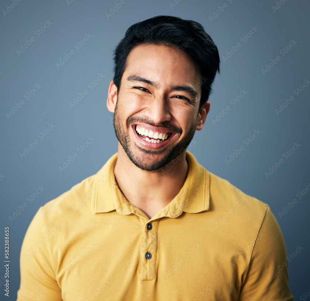 Portrait, happy and carefree with a man in studio on a blue background ...