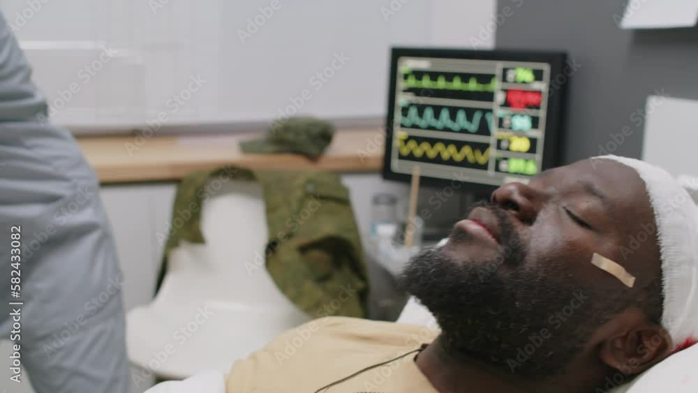 Black soldier with bullet wound in head suffering agony, doctor ...