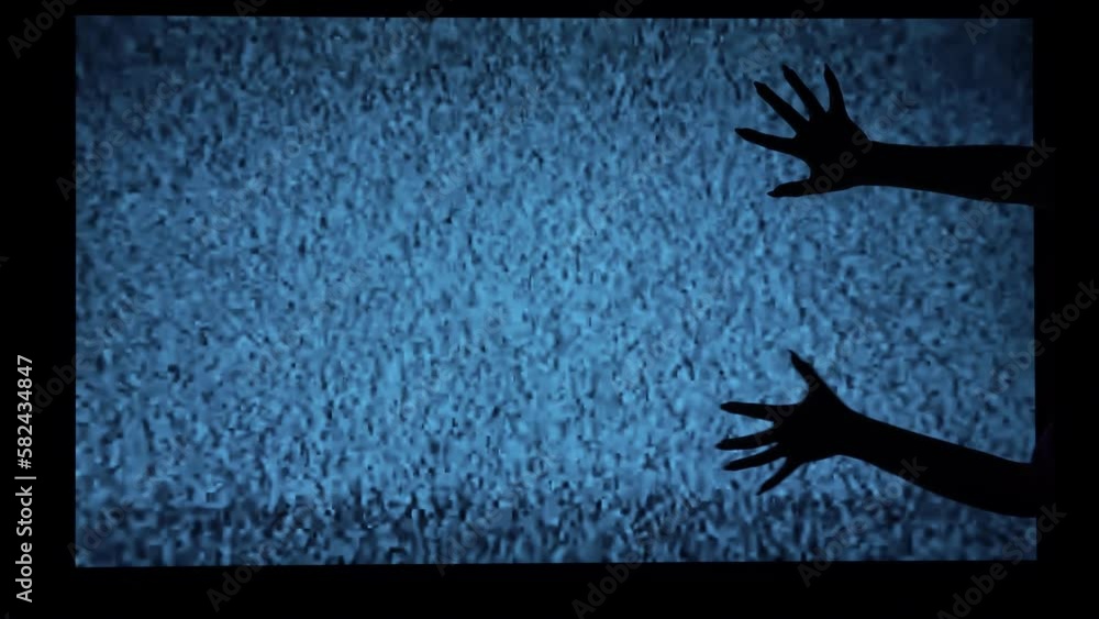 Stockvideon Hands on the background of the noise of the TV scary scene ...