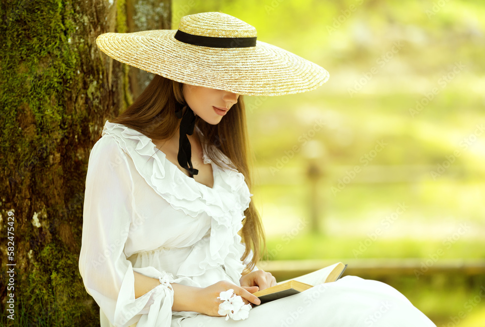 Romantic Girl in White Dress and Straw Sun Hat reading Book sitting ...