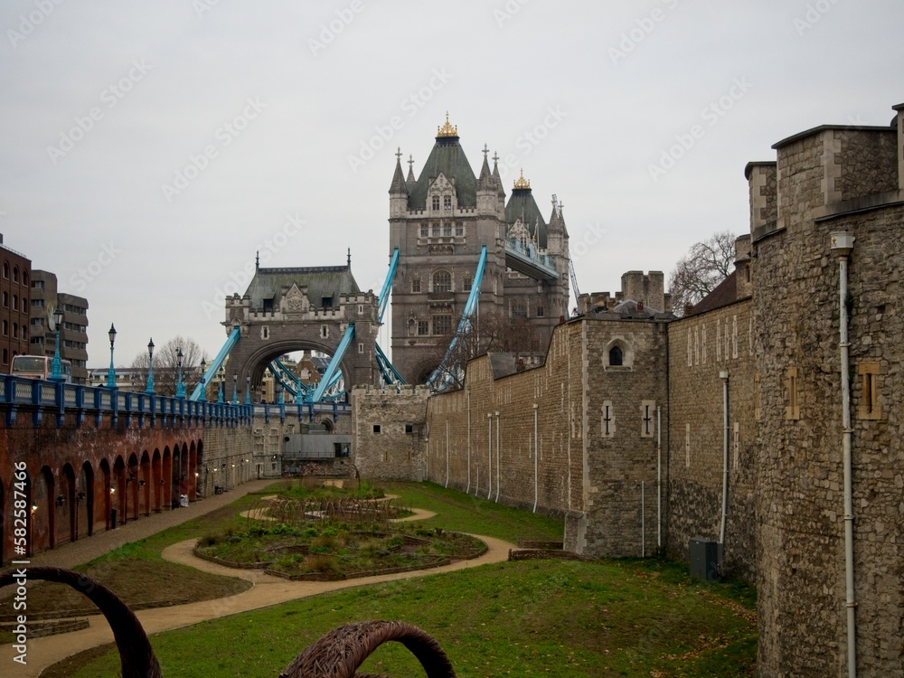 The Tower Bridge rises over the grounds of the Tower of London, a ...