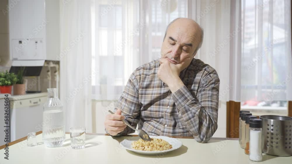 Unhappy thoughtful old man does not eat in the kitchen. The old man ...