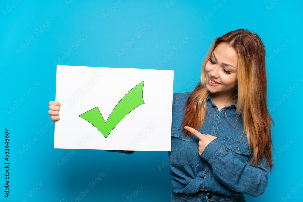 Teenager girl over isolated blue background holding a placard with text ...