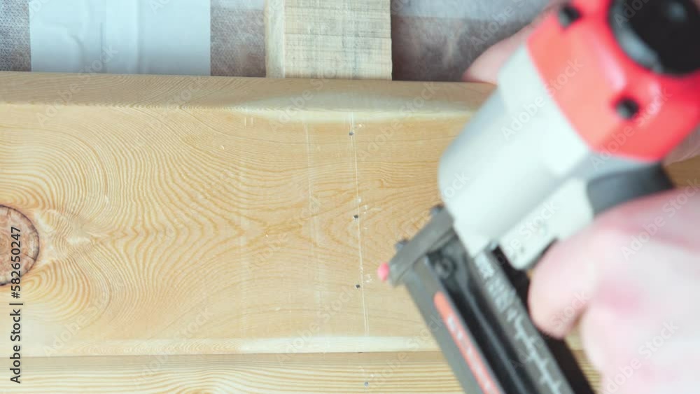 Video of carpenter male hands working with pneumatic stapler for wooden ...