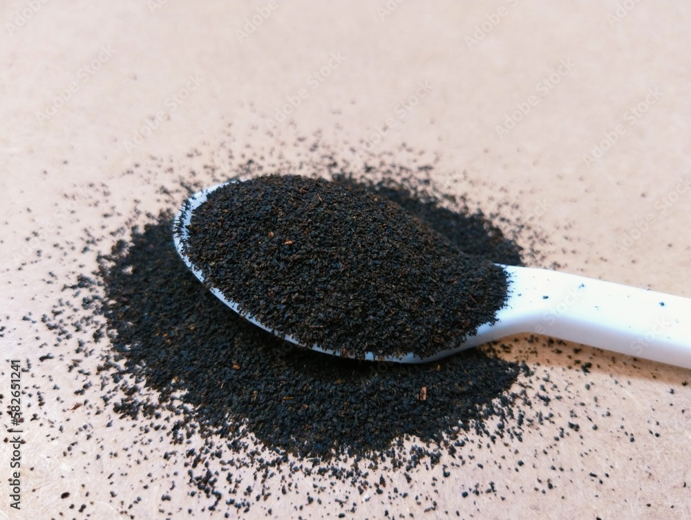 Black tea dust dried and grinded tea-leaves powder on spoon lose leaf ...
