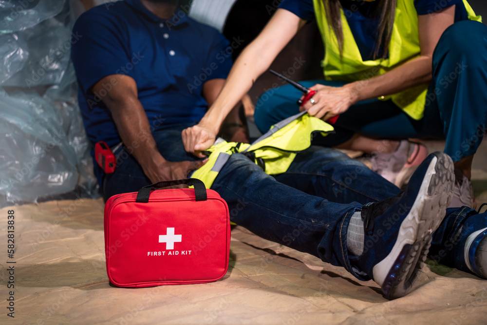 Emergency staff in safety suit help a man who has knee injuries from ...