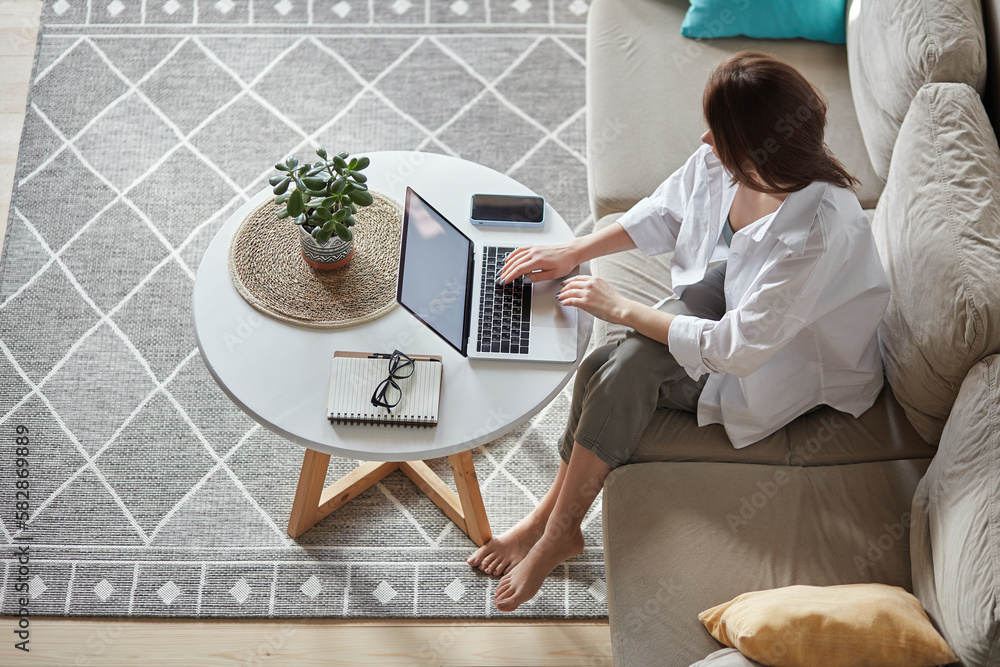 Mockup white screen laptop woman using computer sitting on sofa at home ...