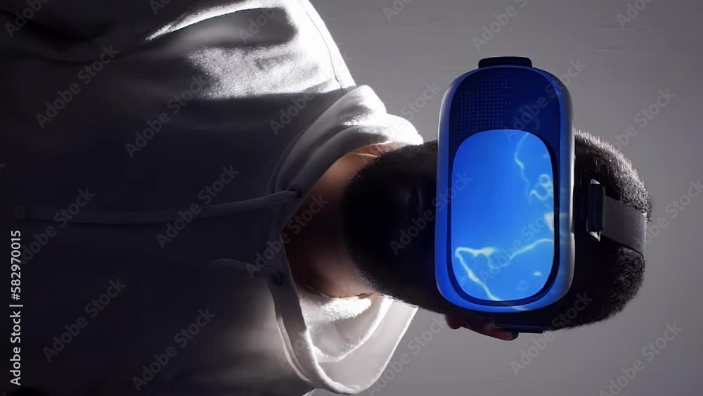 Blue lightning animation overlay over VR goggles worn by man; vertical ...