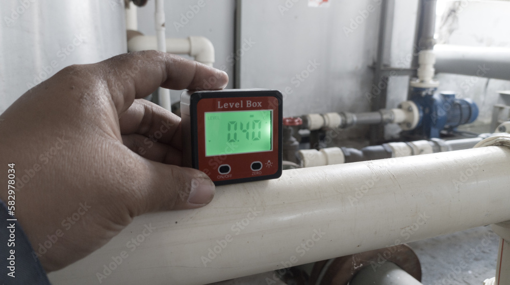 The Plumber Intalling Pipe Leveling used Digital Magnetic Level ...