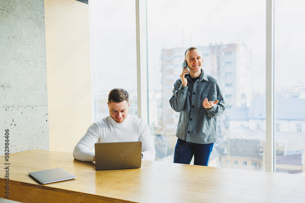 Two confident young people are sitting together at a table and one of ...