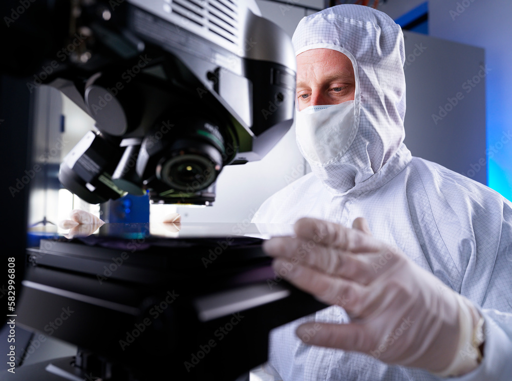 Engineer checking silicon wafer chip using semiconductor in laboratory ...