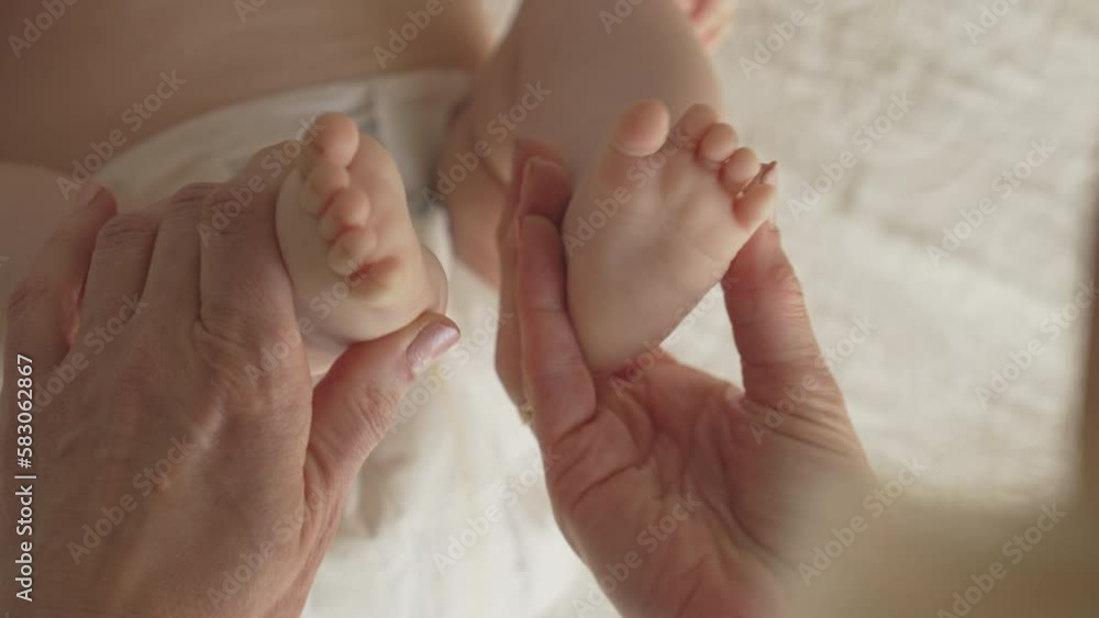newborn baby feet and toes, mom massages with both hands, white ...