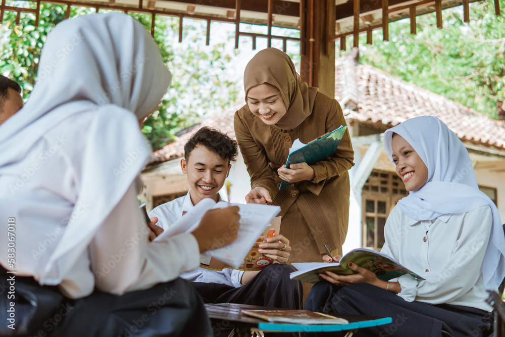 Asian female teacher accompanies students while studying in outdoor ...