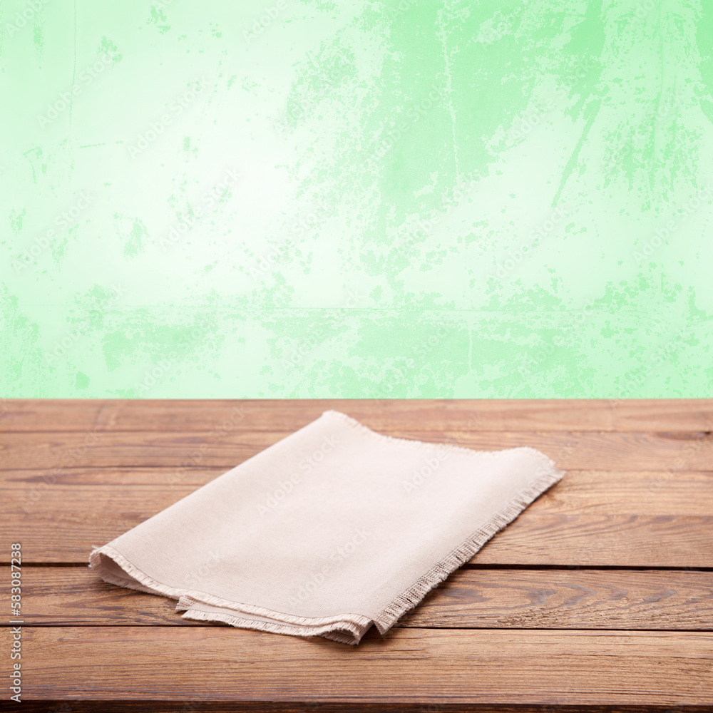 Empty tablecloth on wooden table with spring green background. Napkin ...