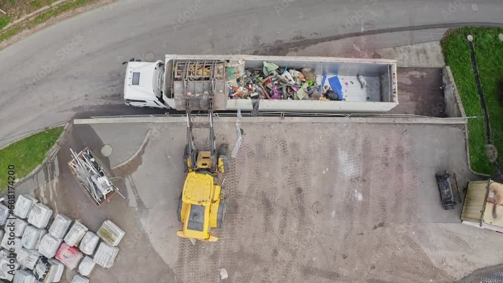 Skid steer loader loading a truck with waste material transferred for ...