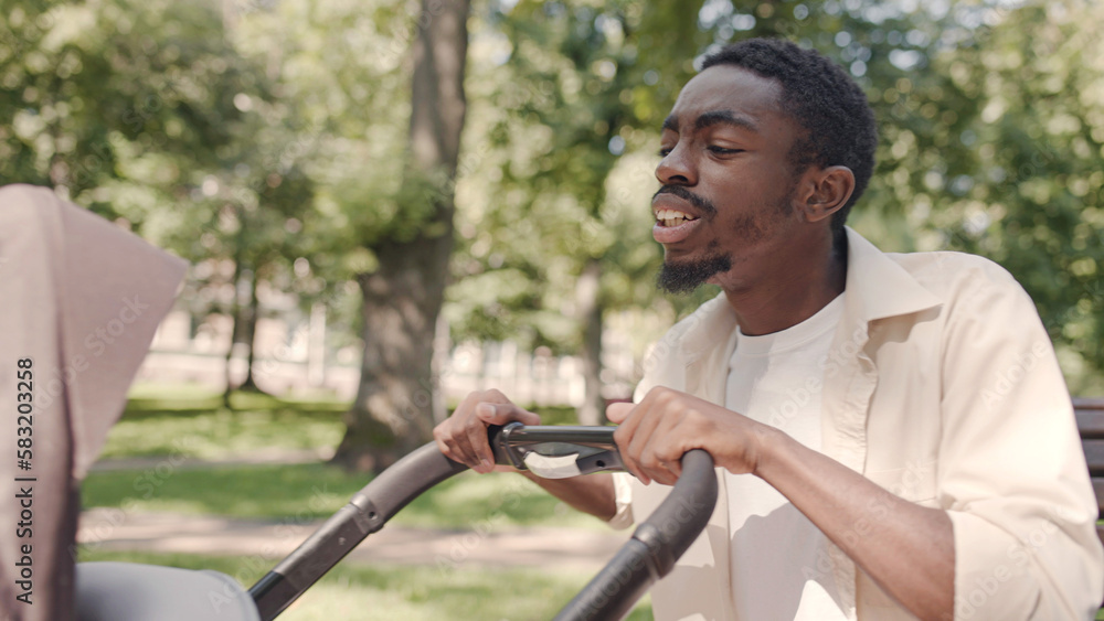 Anxious father rocking baby stroller, trying to calm down little crying ...