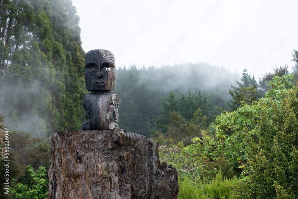 Maori tiki statue surrounded by mist in Waikato Aotearoa New Zealand in ...
