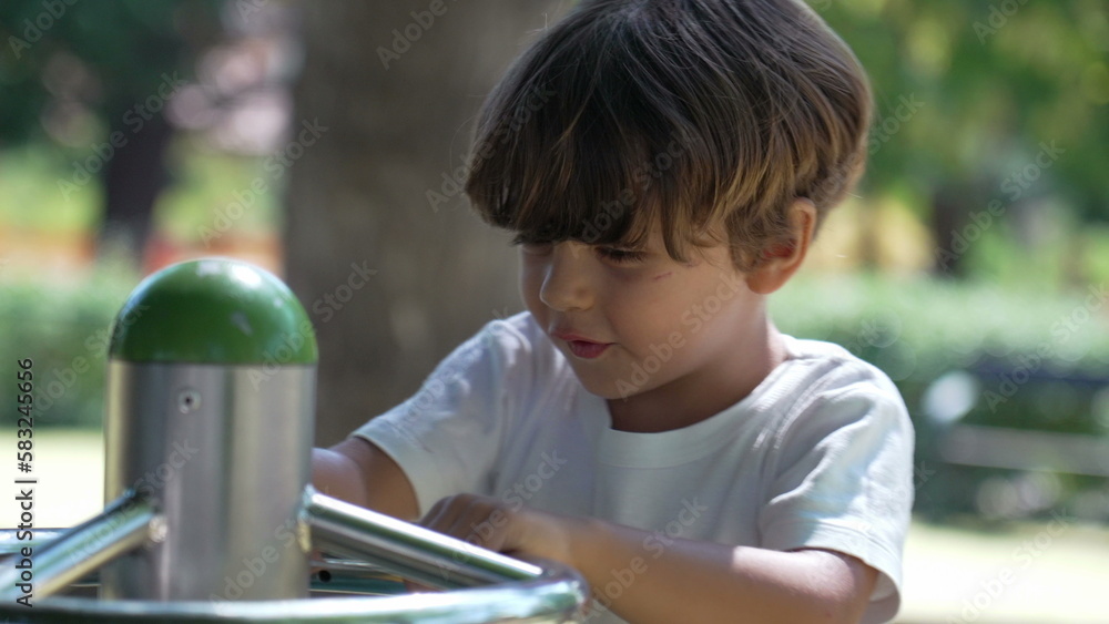 One small boy playing at playground carousel turning around. Kid in ...