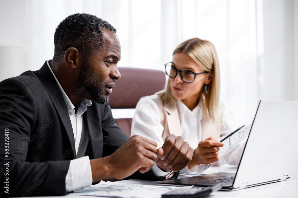 Foto Stock Two people analyze documents on a laptop while sitting at a ...