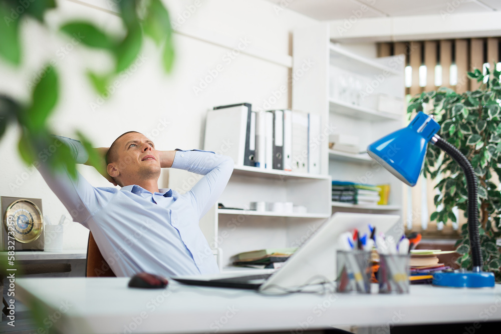 Relaxed office worker sitting at workplace, distracted from working on ...