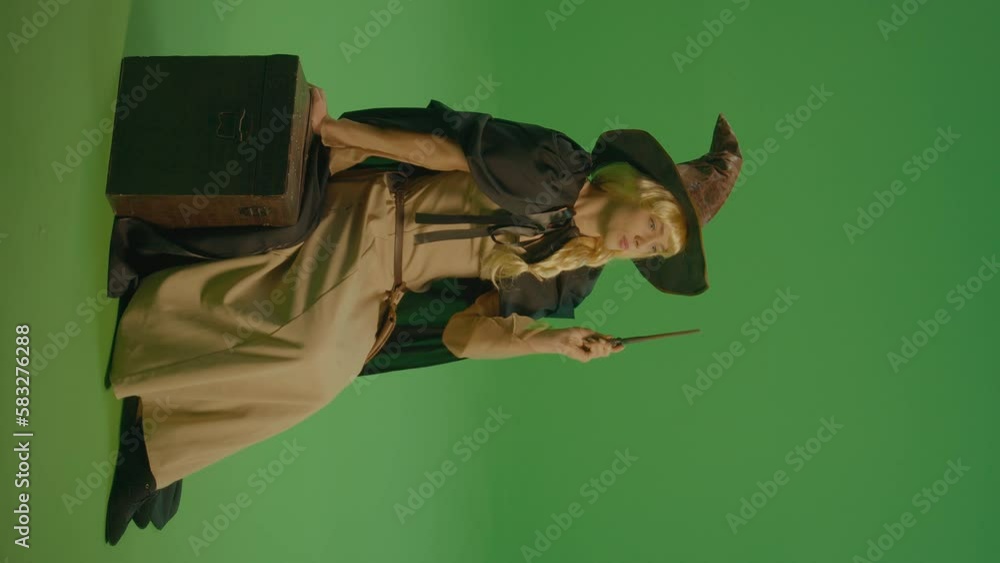 Vertical View.Green Screen. Woman Sorceress With a Magic Wand Sitting ...