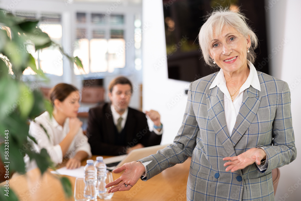 Portrait of friendly polite senior female entrepreneur standing in ...