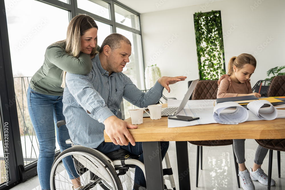 A physically challenged father works from home, supported by his family ...