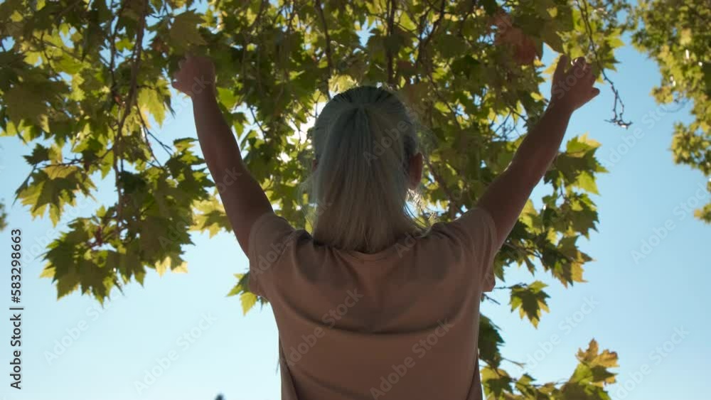 Teen enjoy blue sky by tree. A friendly teen girl admire the nature in ...