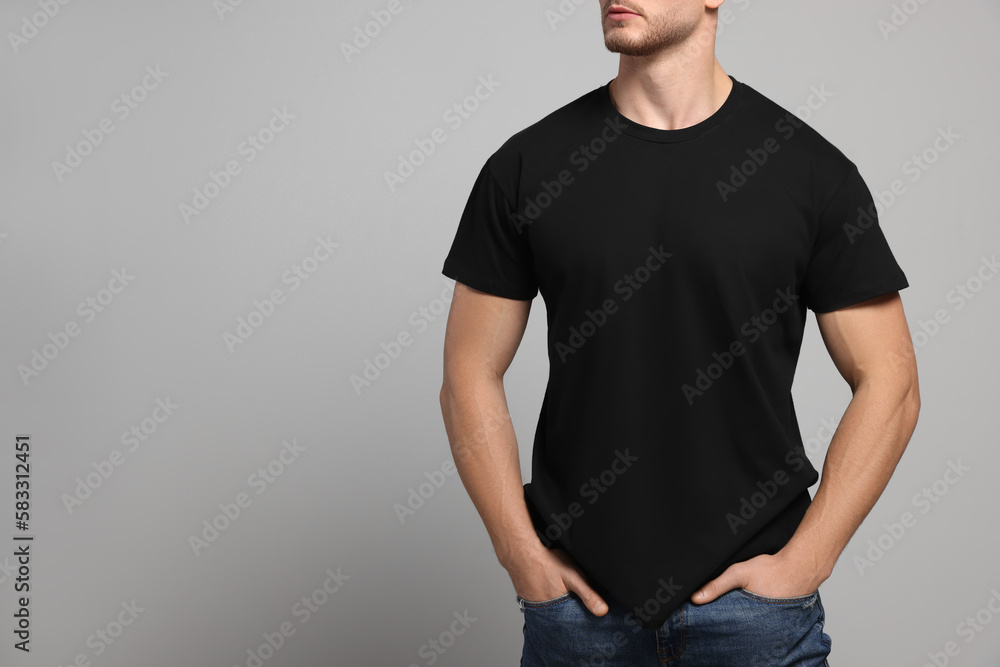 Man wearing black t-shirt on light grey background, closeup. Mockup for ...