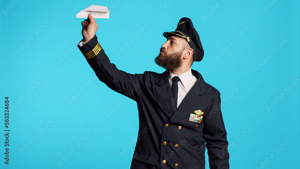 Young man working as pilot building paper plane, having fun with ...