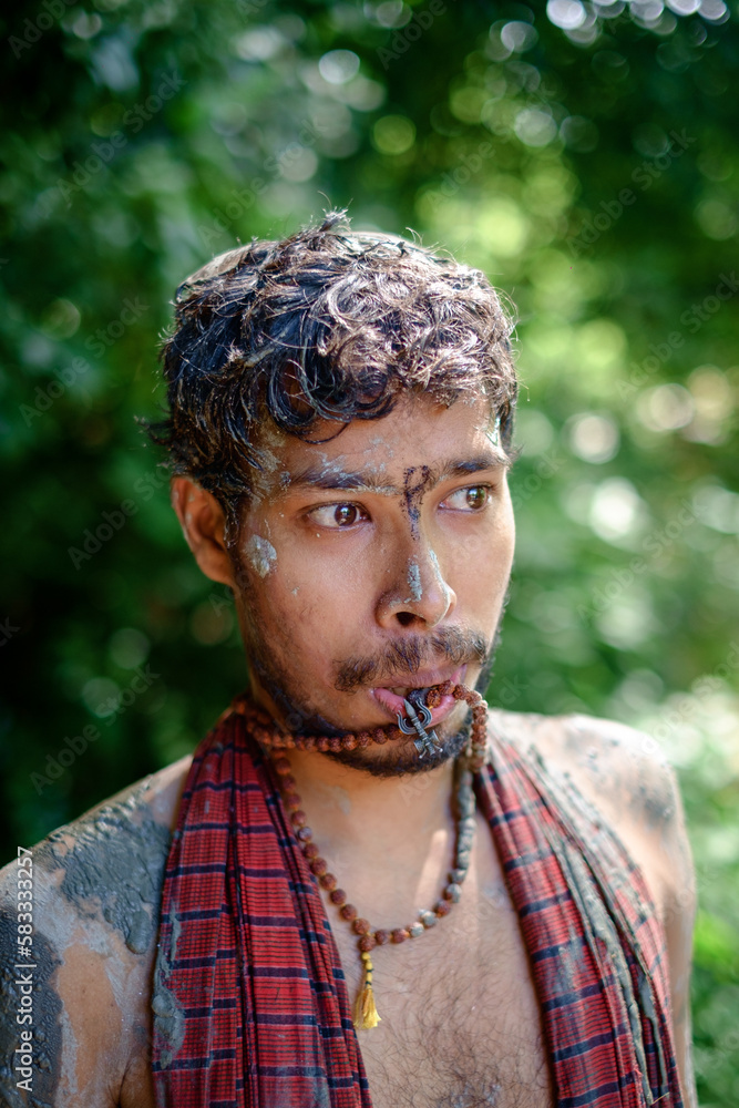South asian hindu religious young aged handsome man playing with mud in ...