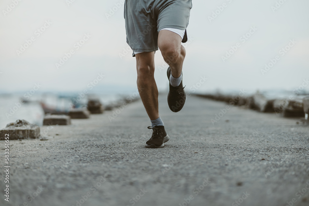 healthy lifestyle young fitness man running at seaside old bridge ...