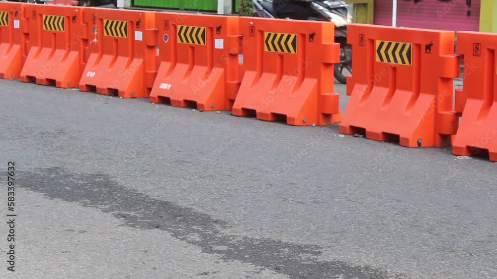Vídeo do Stock: Bright orange road dividers serve as a crucial safety ...