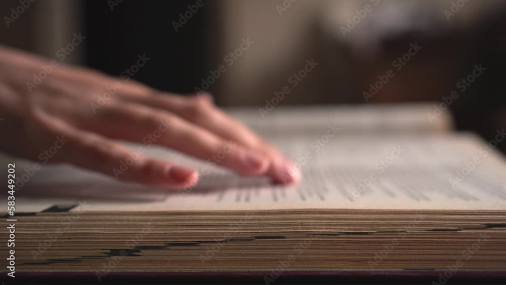 Hand turning pages of a book. Slow motion. Person's hand reading a book ...