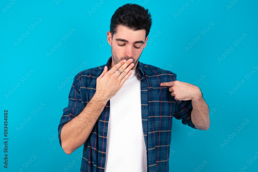 Shocked Young man standing over blue studio background look surprisedly ...