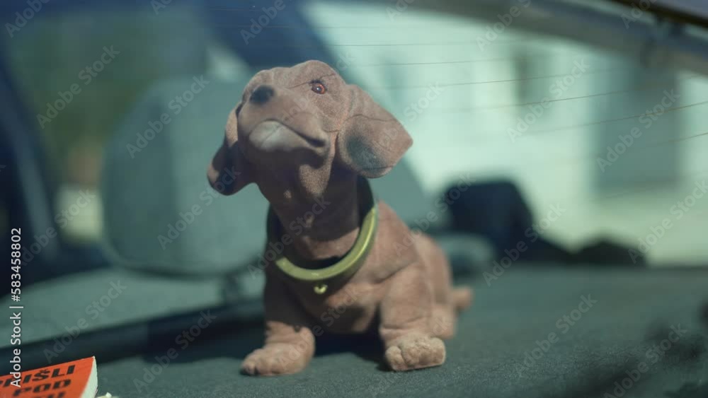 Retro nodding brown bobble head dog under rear car window windscreen ...