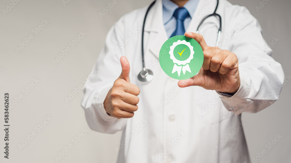 Doctor holding a quality assurance symbol while standing in the ...
