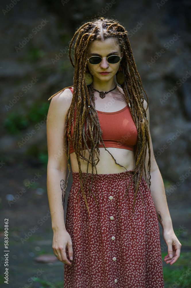 Beautiful girl with dreadlocks, dressed hippie style,poses outdoors ...