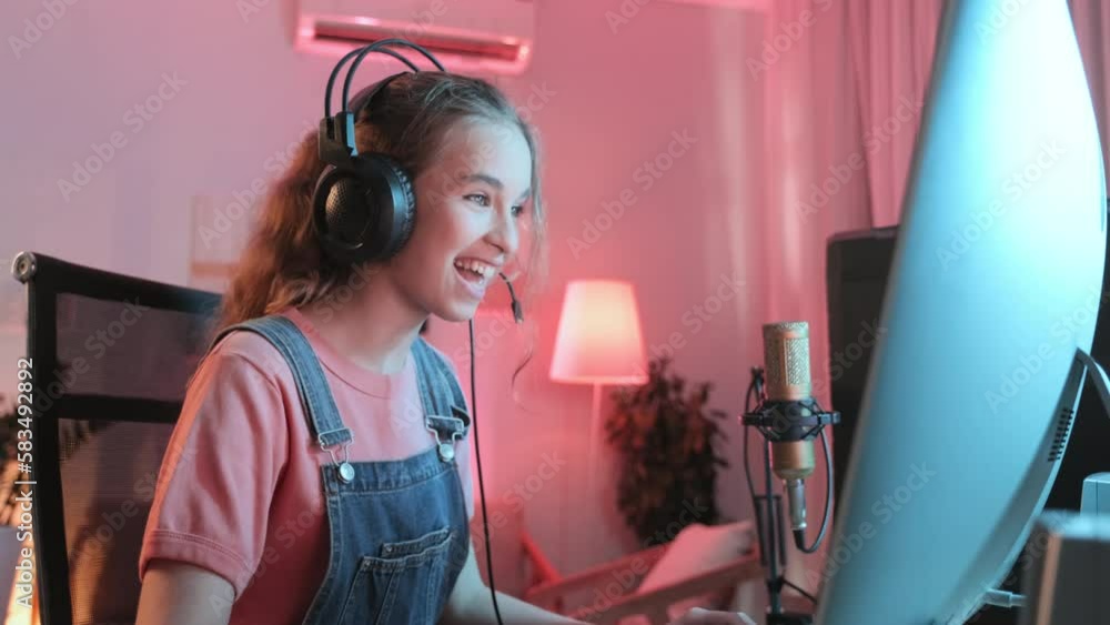 Waist up of Caucasian gen z girl in headphones having fun while playing ...