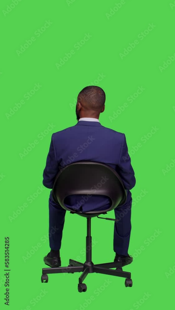Vertical video: Back view of male company entrepreneur sitting on chair ...