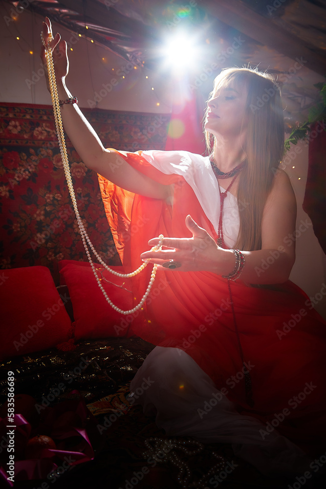 Beautiful European girl looking like Arab woman in red room with rich ...