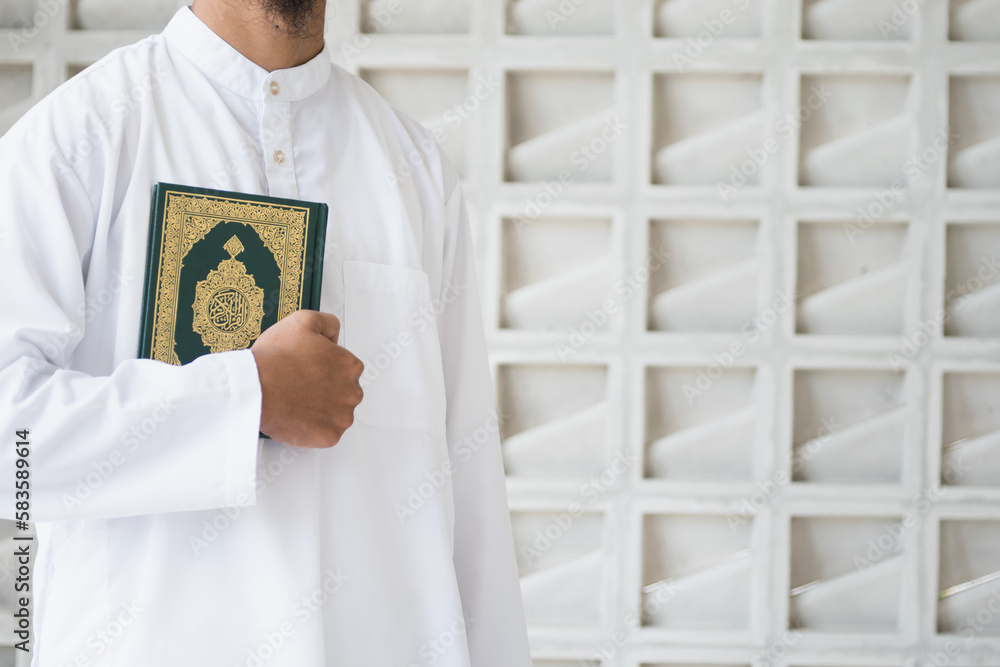 Holy Quran in Hand with arabic calligraphy meaning of Al Quran. Muslim ...