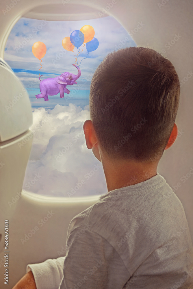 Little boy looking out of window while flying on an airplane.Elephant ...