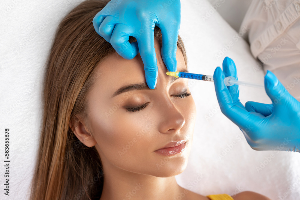 Cosmetologist makes rejuvenating anti wrinkle injections on the face of ...