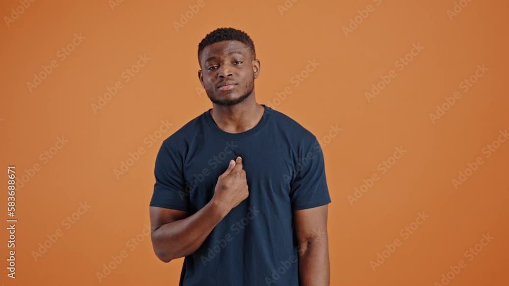 African guy looking attentively at camera, questioning and pointing at ...